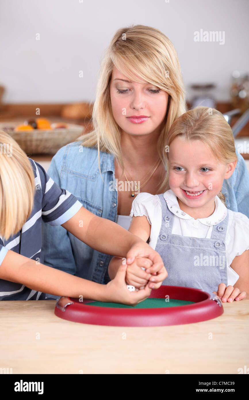 Family playing game with dice Stock Photo - Alamy