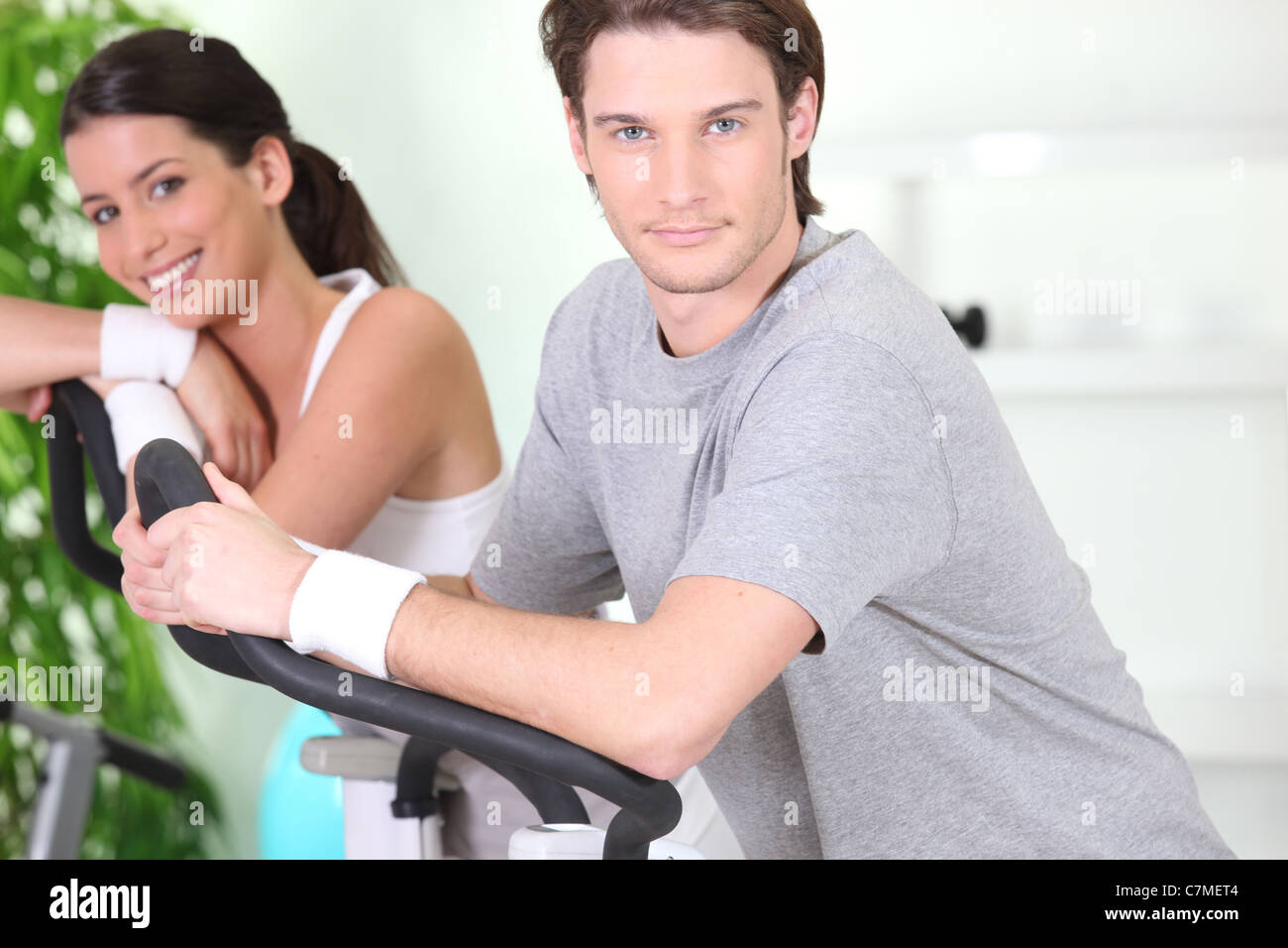 Couple using running machines Stock Photo - Alamy