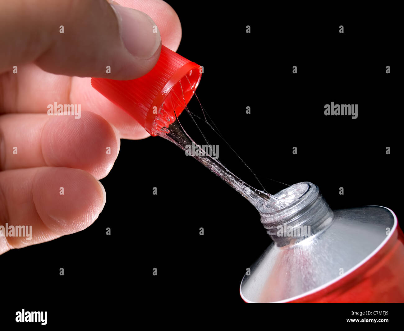 Closeup view during the opening of the glue tube Stock Photo - Alamy