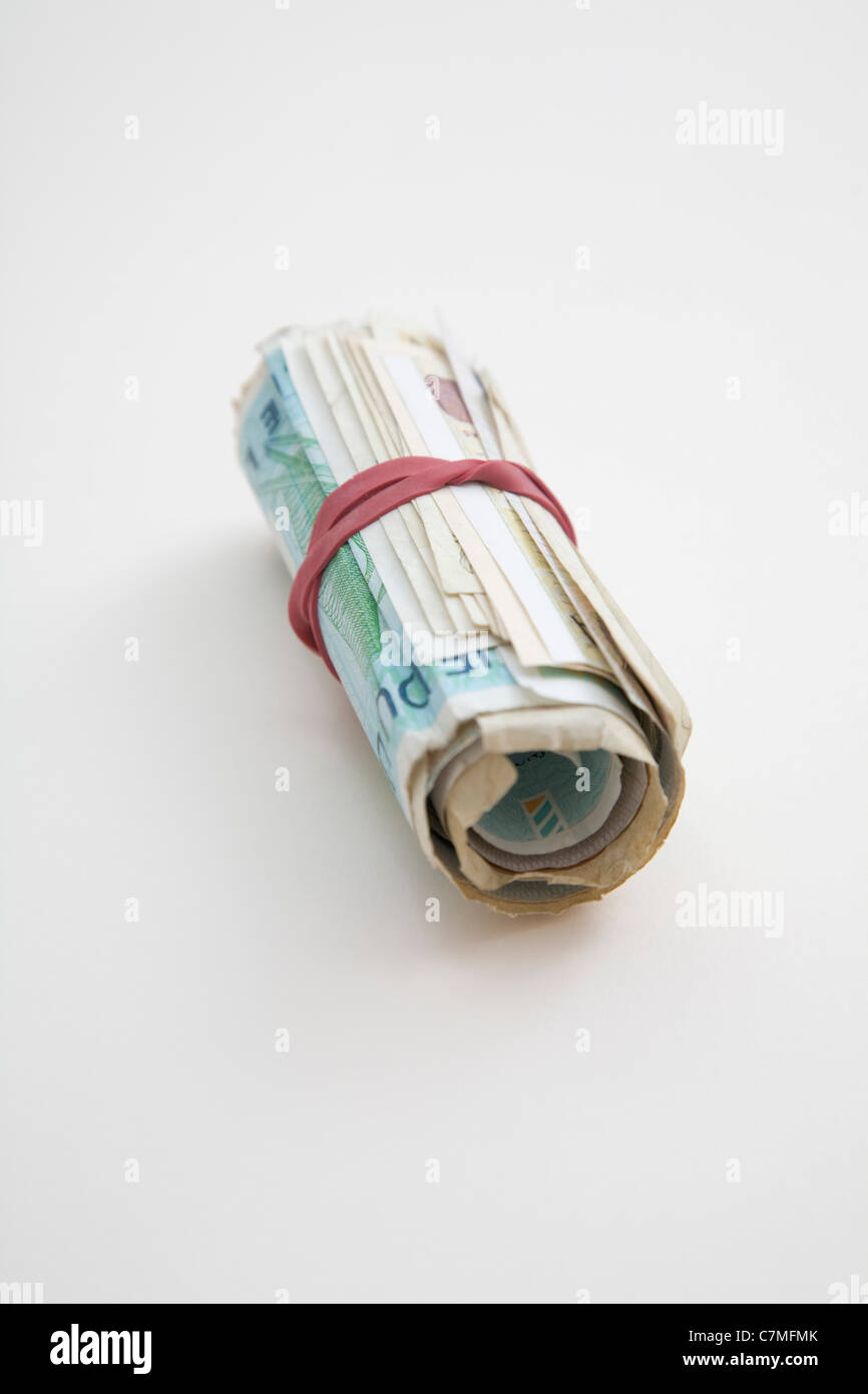 Roll of foreign money tied in a rubber band Stock Photo - Alamy