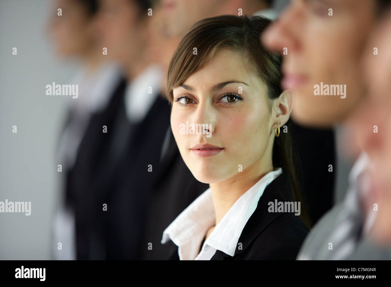 Young woman standing in line with co-workers Stock Photo - Alamy