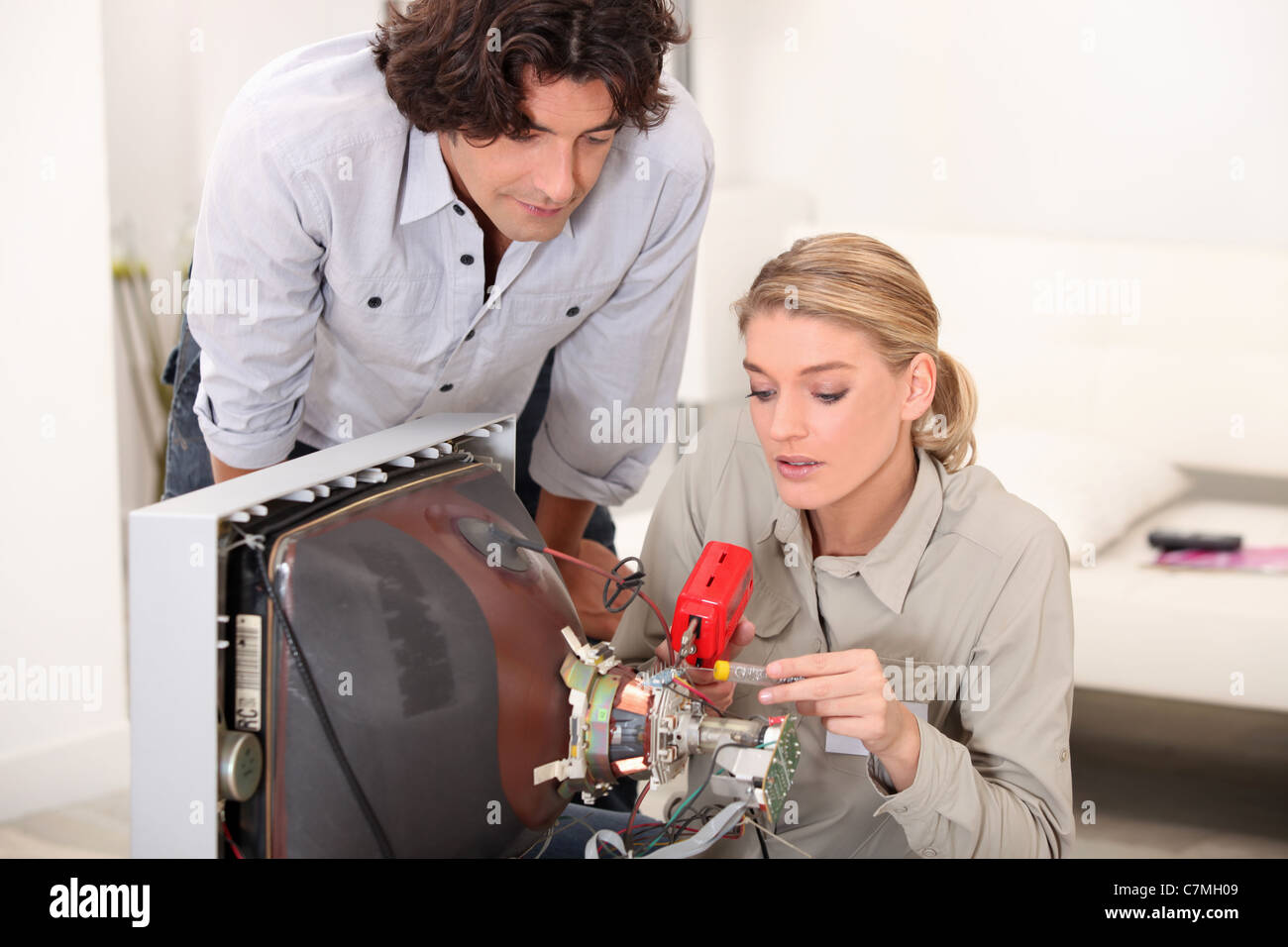 Woman repairing television Stock Photo - Alamy