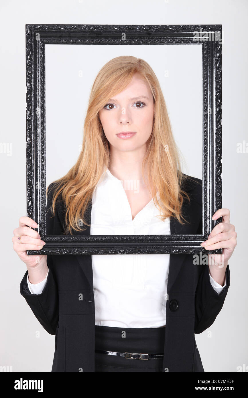 Woman holding up a picture frame Stock Photo - Alamy