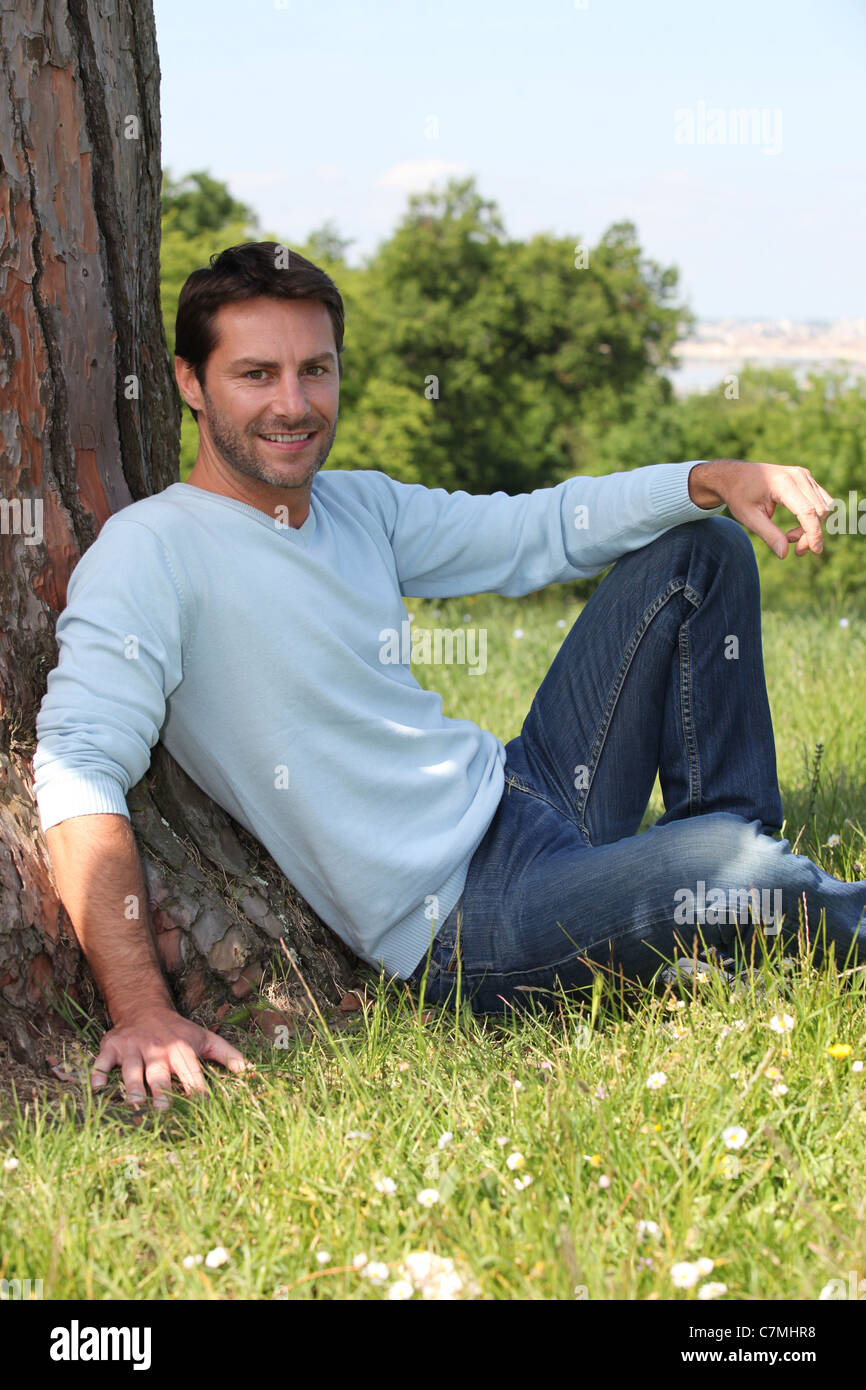 Man sitting under a tree Stock Photo - Alamy