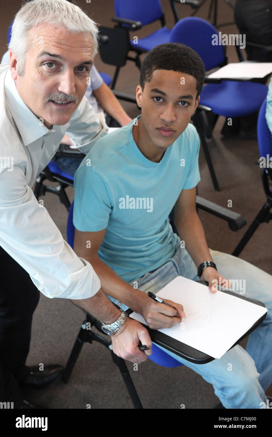 Teacher helping his student with his assignment Stock Photo - Alamy