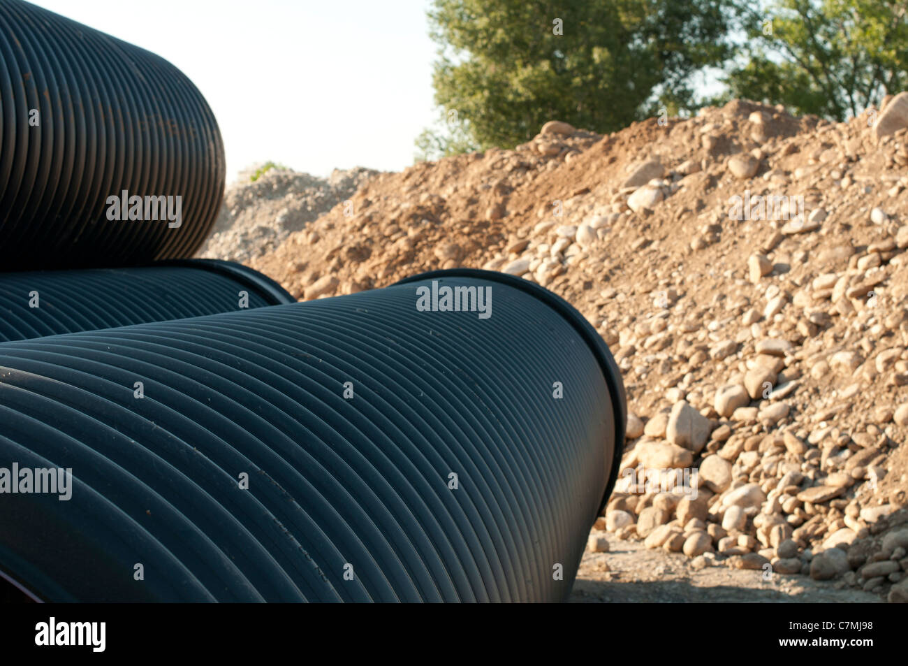 Black pipes and piles of sand in the background Stock Photo - Alamy