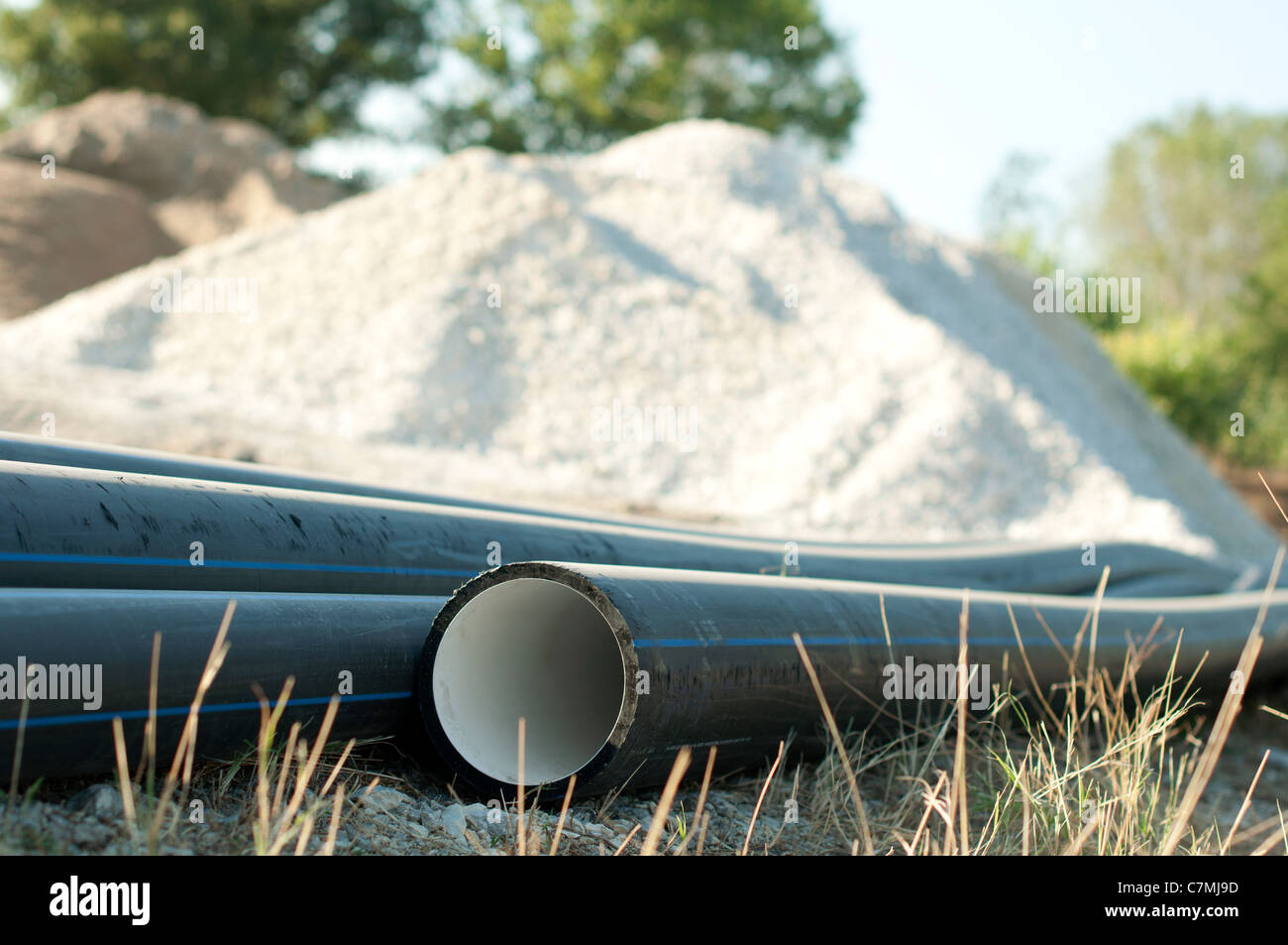 Black pipes and piles of sand in the background Stock Photo - Alamy