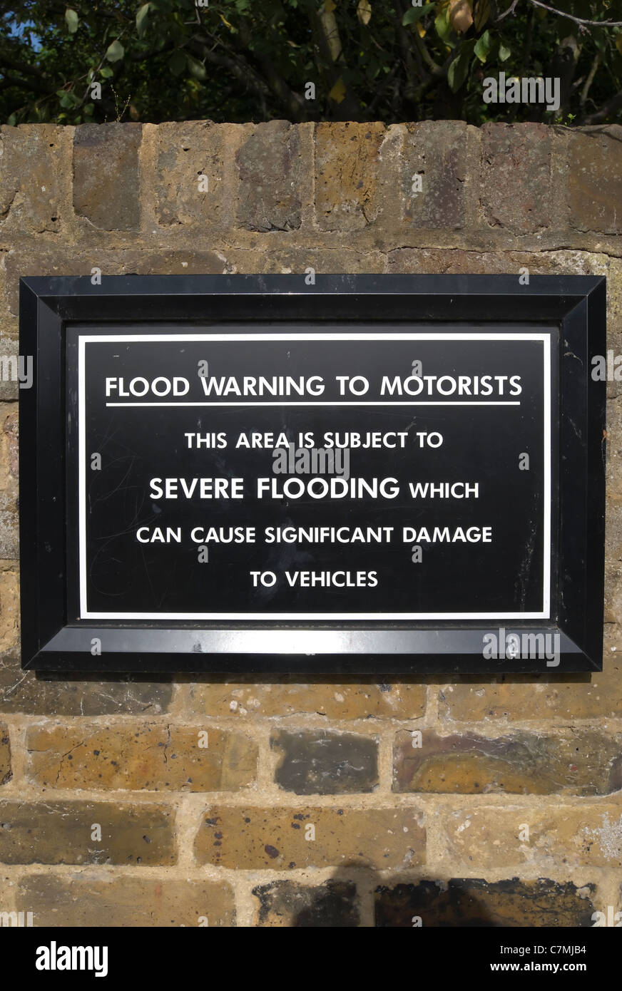 flood warning sign on chiswick mall, beside the river thames in london ...