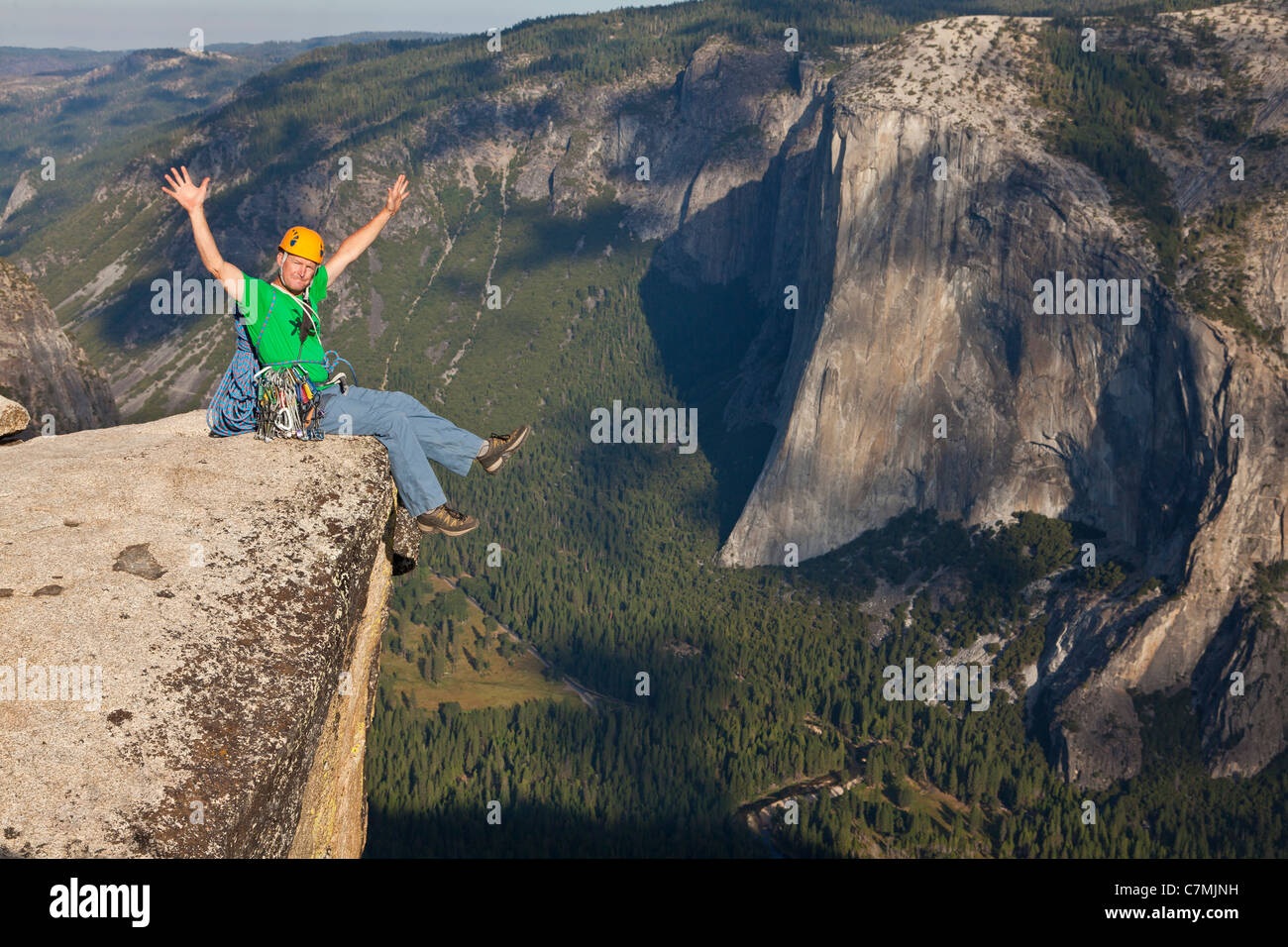 Male rock climber celebrates on the summit after a successful ascent ...