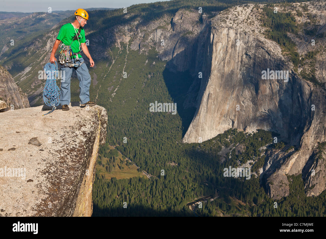 Male rock climber celebrates on the summit after a successful ascent ...