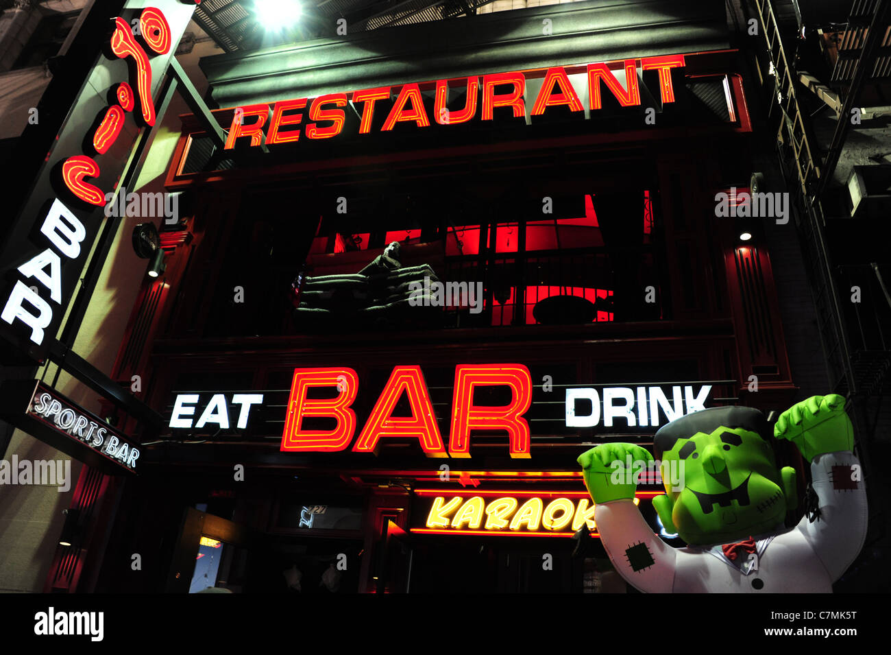 Green waiter doll standing front red white neon facade Tonic Restaurant ...