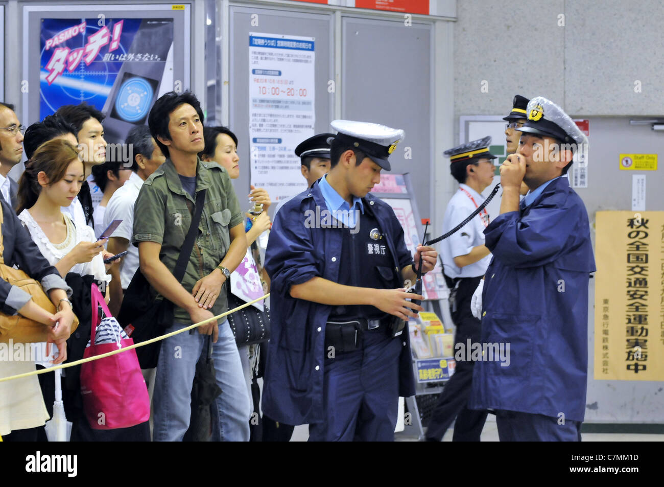 Passengers wait for the resumption of train services at Shibuya station ...