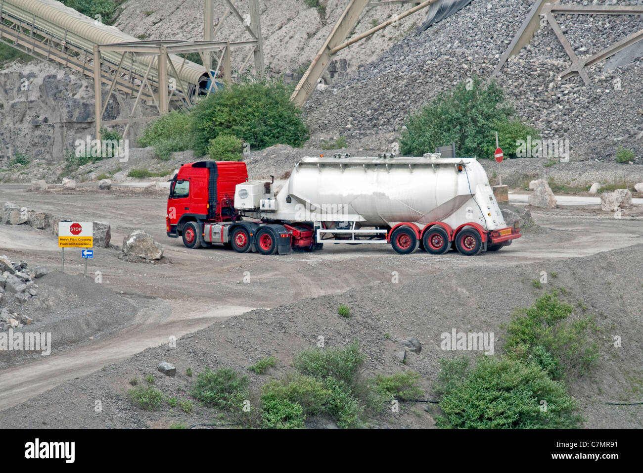 A red lorry enters a quarry in South Wales, carrying a load of cement ...