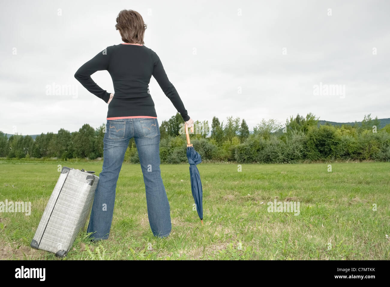 Rear view of a young woman standing on a meadow Stock Photo - Alamy