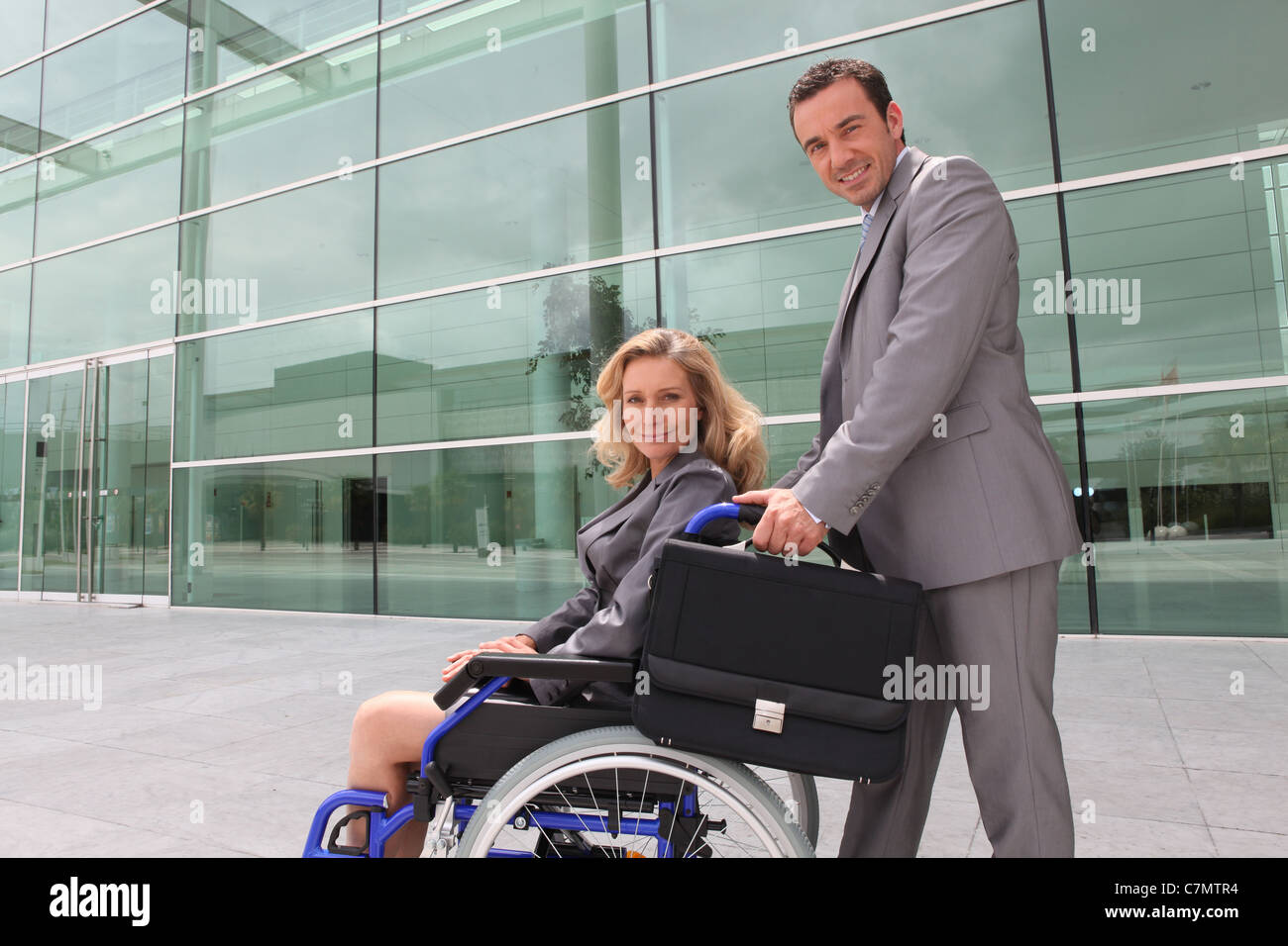 woman in a wheelchair and man helping Stock Photo - Alamy