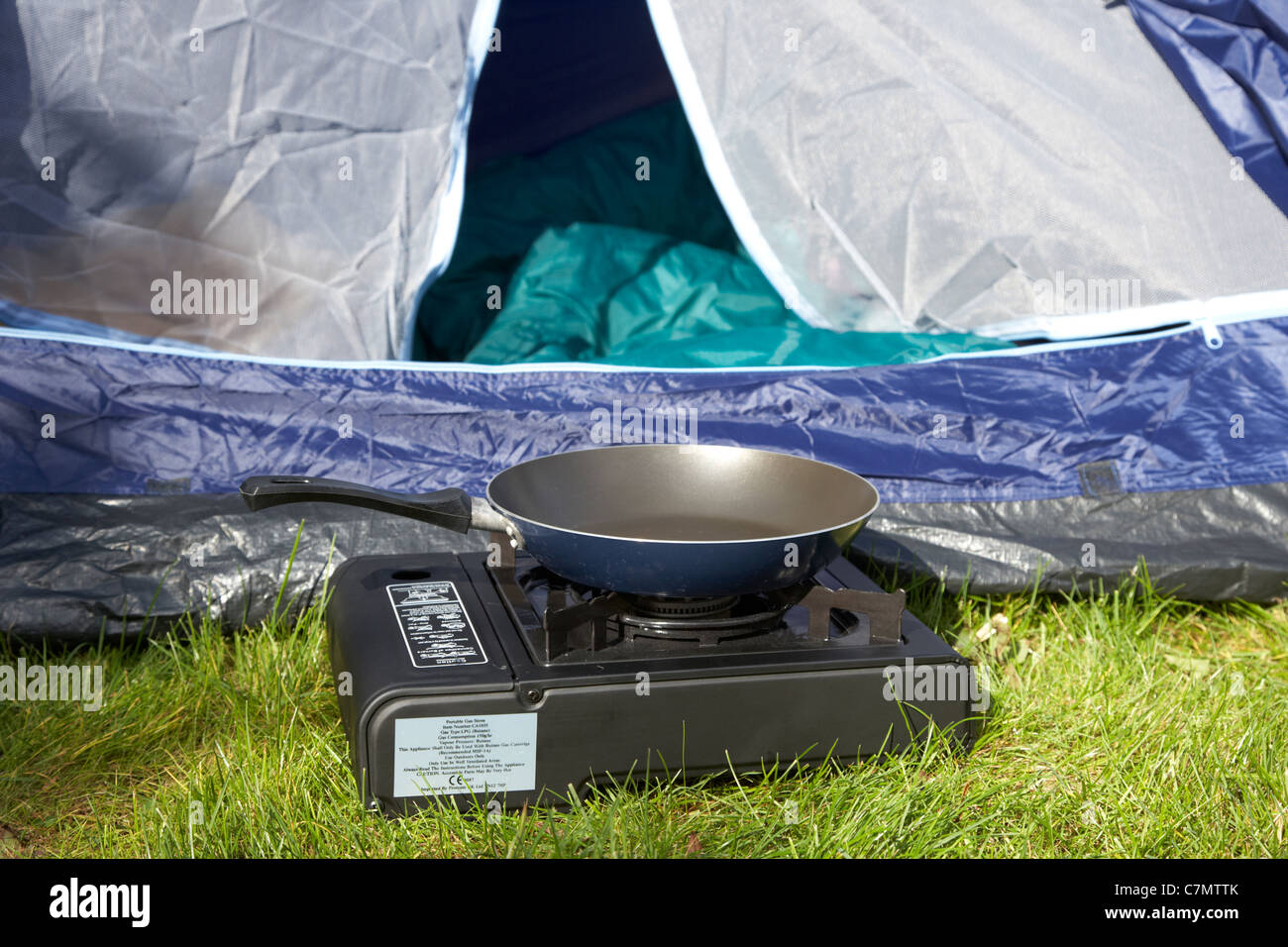 heating up a small frying pan for cooking on a small portable gas ...