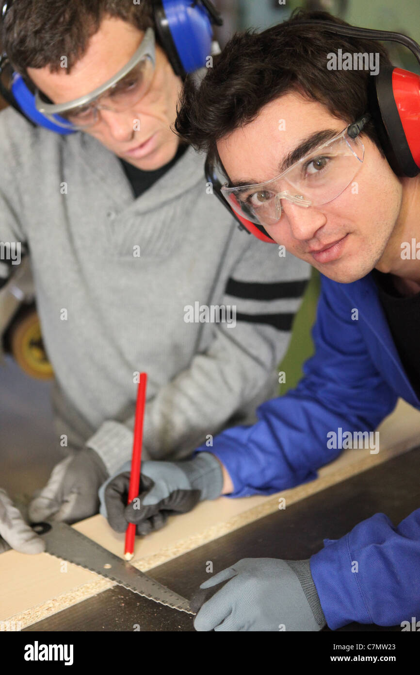 Apprentice marking a piece of wood Stock Photo - Alamy