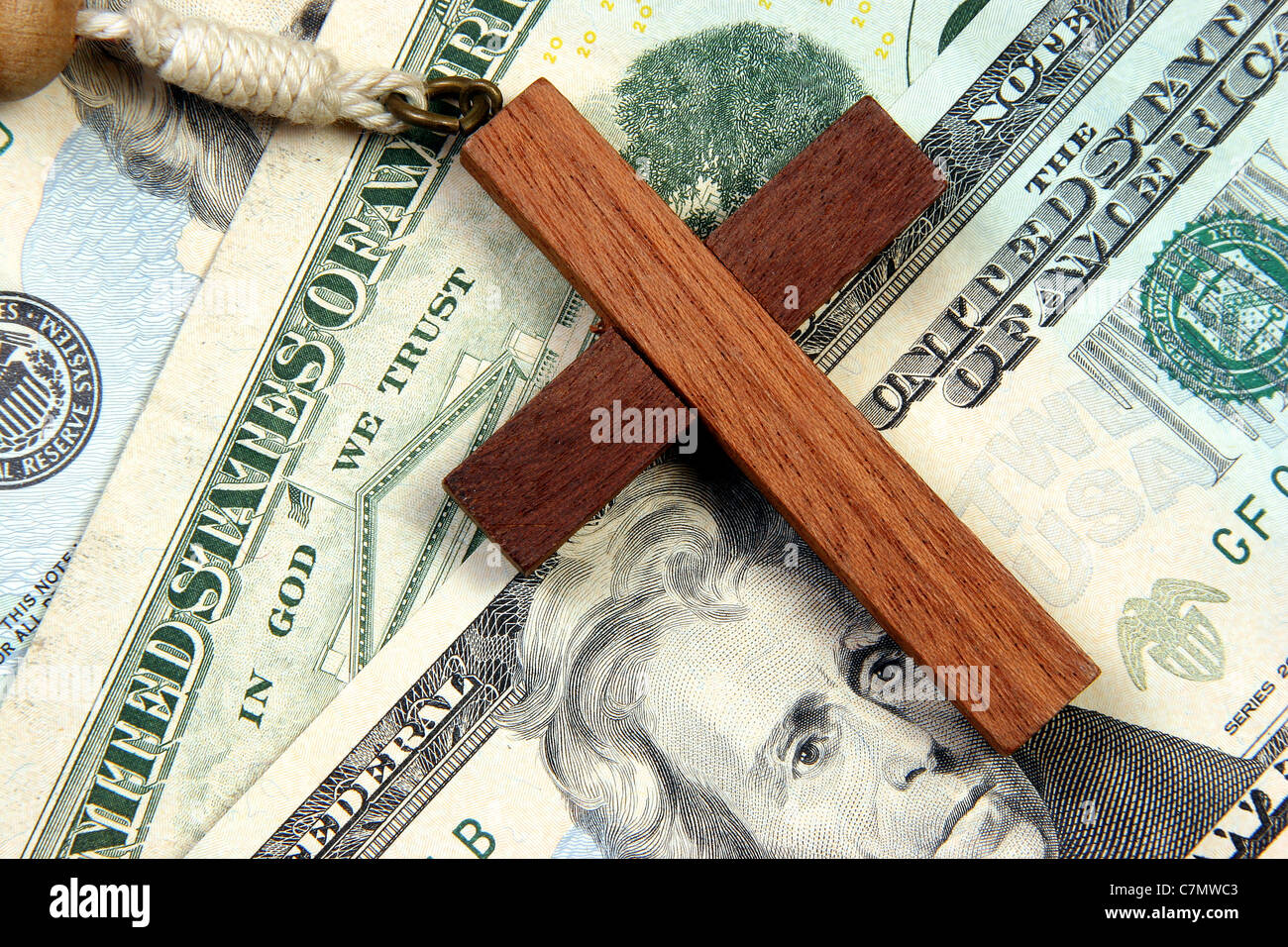 A wooden cross over a stack of money with the words in god we trust ...