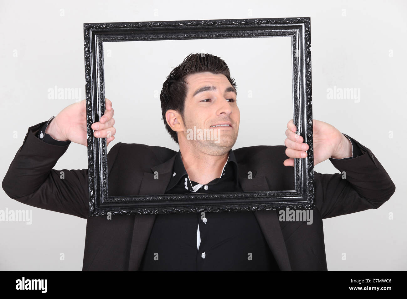 Man trying to escape a picture frame Stock Photo - Alamy