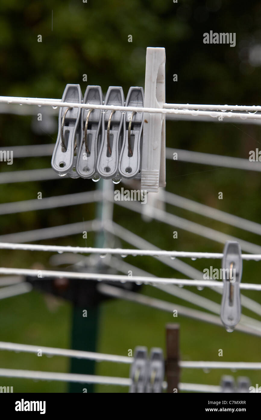 used plastic clothes pegs hanging on a wet washing line in heavy rain ...