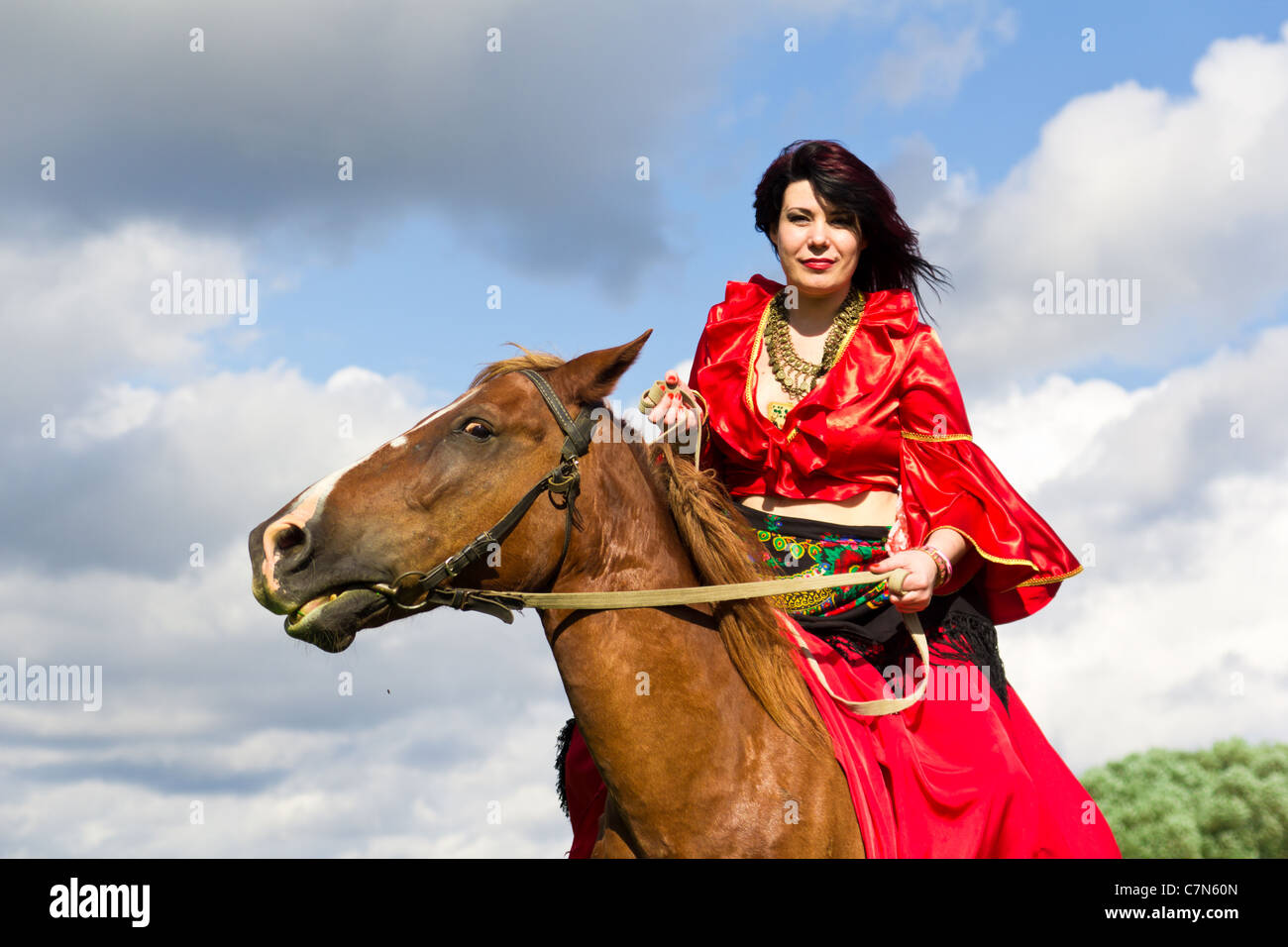 Beautiful gypsy girl riding a horse in the field Stock Photo - Alamy