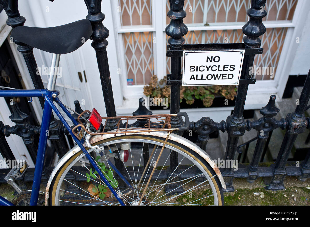 Bicycle leaning against railing with a 'No Bicycles Allowed' sign ...