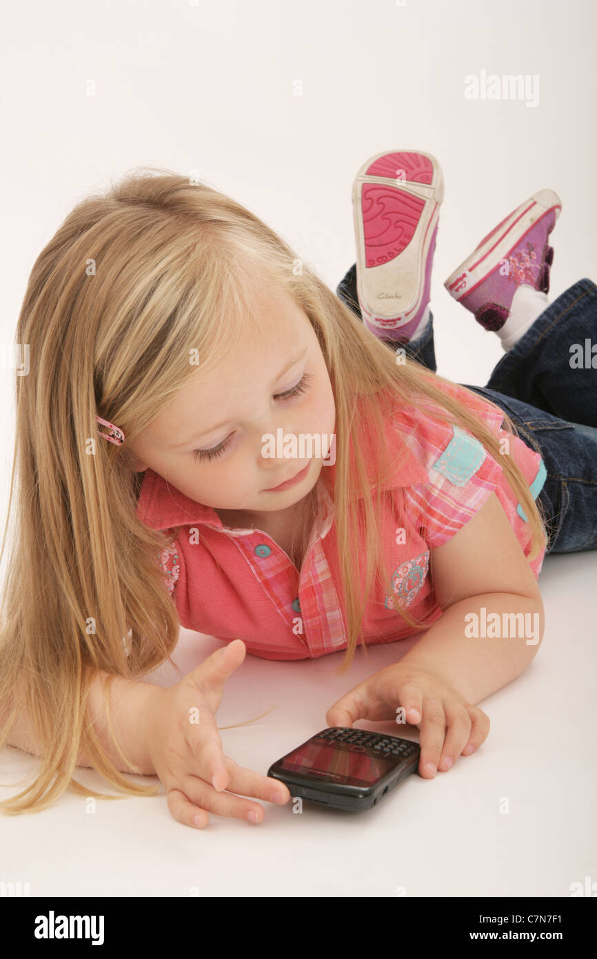 Young girl lying down using a smartphone Stock Photo - Alamy