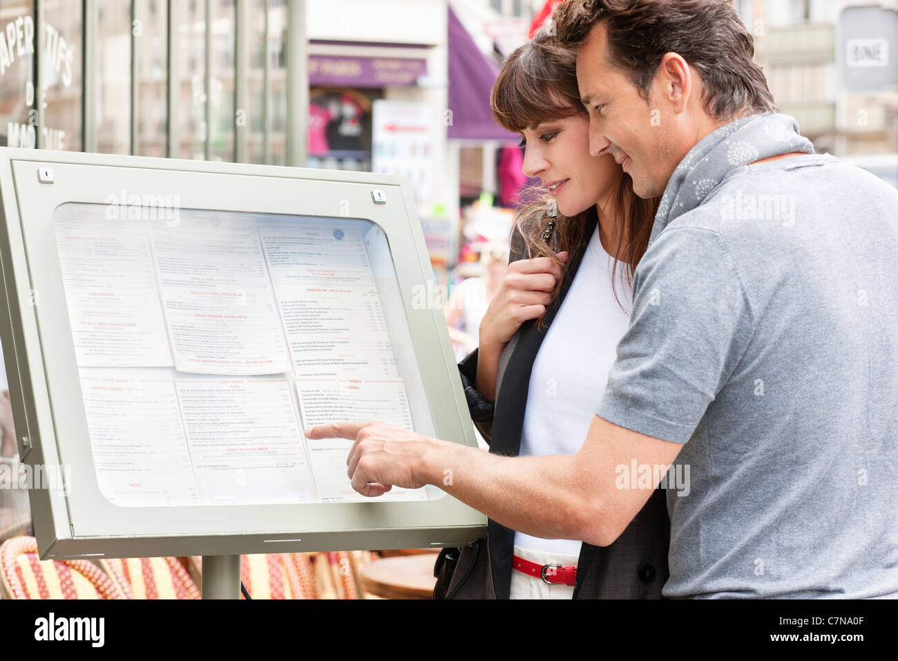 Couple reading menu at a restaurant, Paris, Ile-de-France, France Stock ...