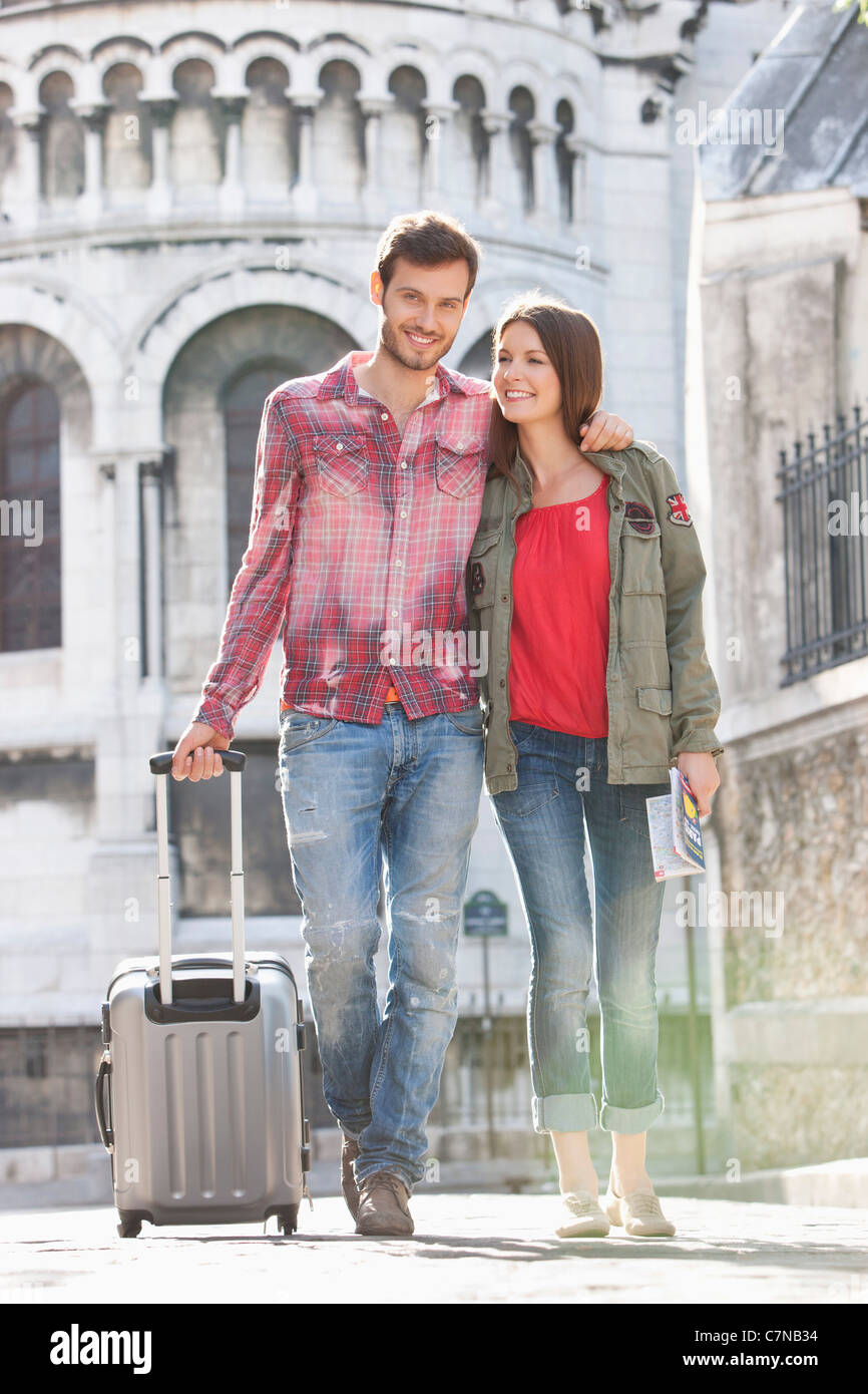 Couple walking on a road with a suitcase, Paris, Ile-de-France, France ...