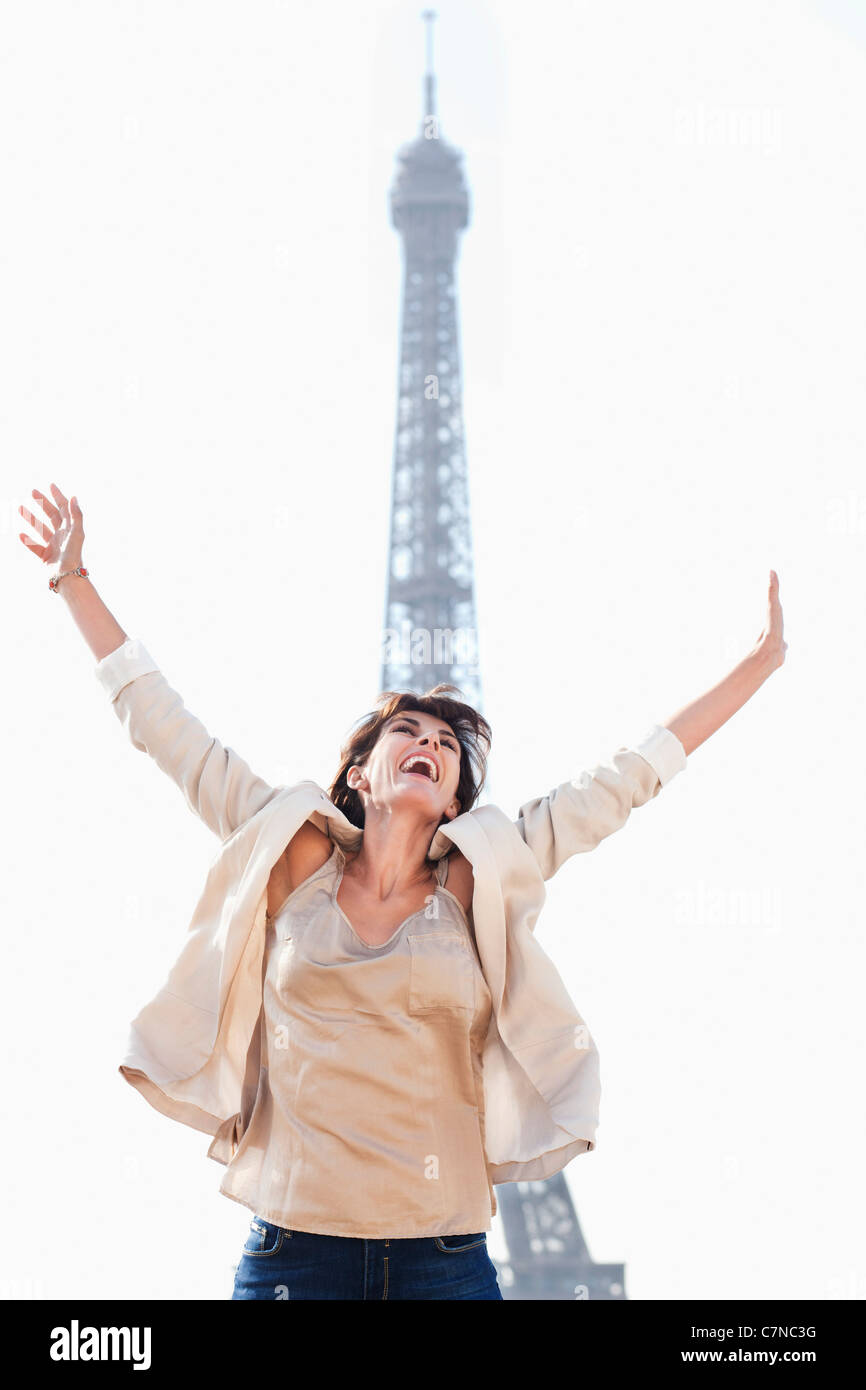 Woman shouting in excitement with the Eiffel Tower in the background ...