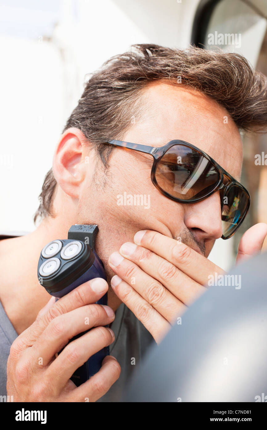 Man using an electric shaver on his face, Paris, Ile-de-France, France ...