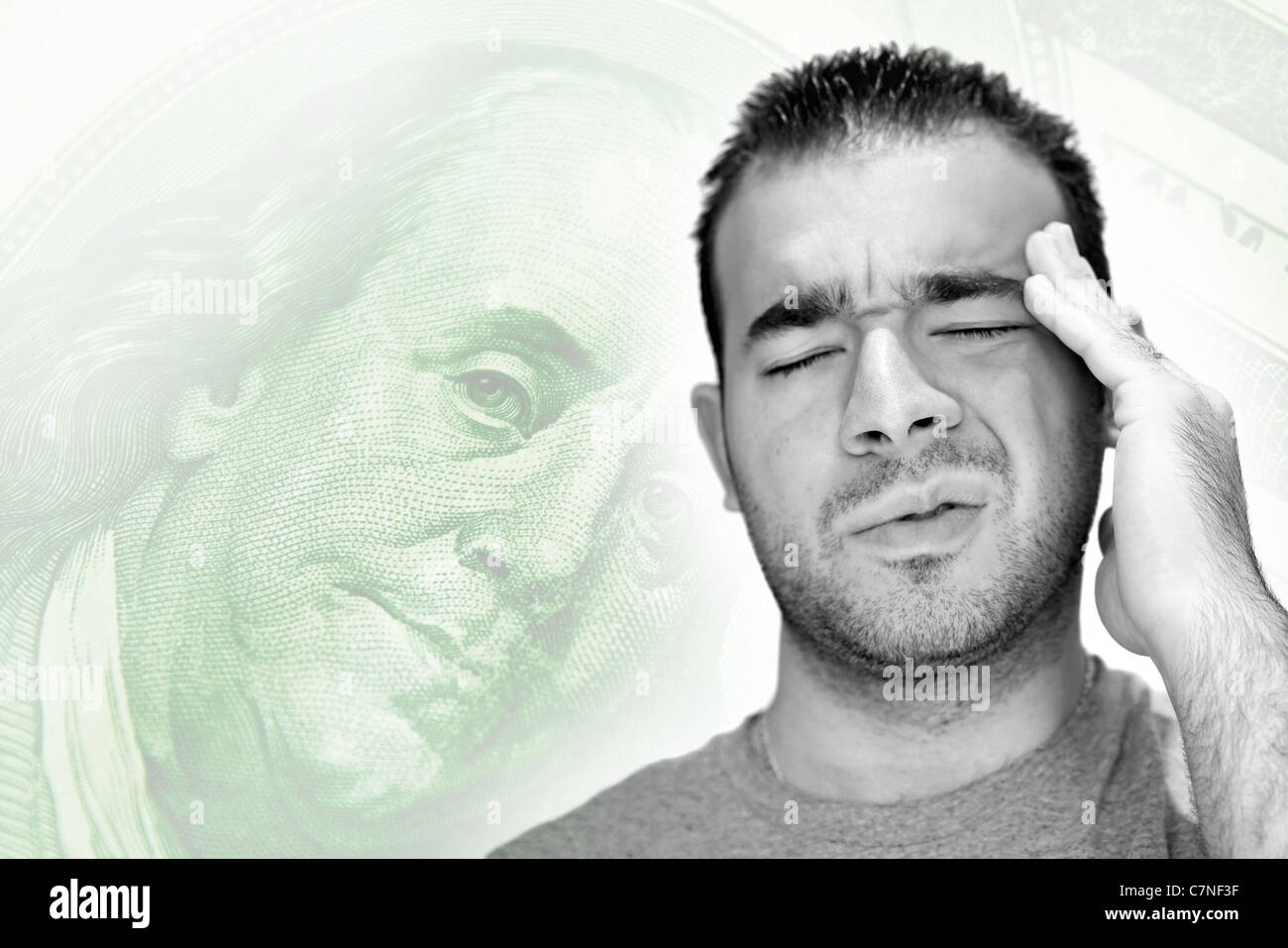 A young man holds his head in anguish as he thinks about his money ...