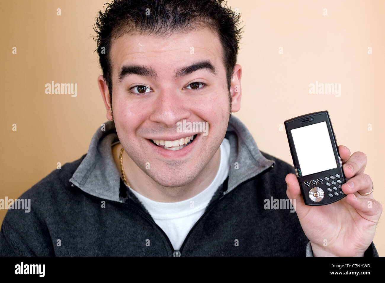 A happy young man showing the screen of a smartphone. The white cell ...
