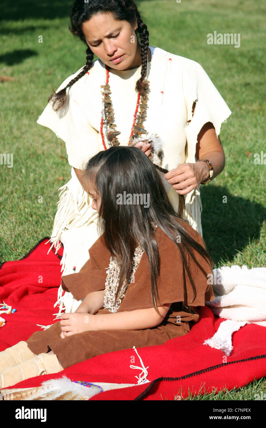 A Native American Indian woman braiding a young childs hair Stock Photo ...