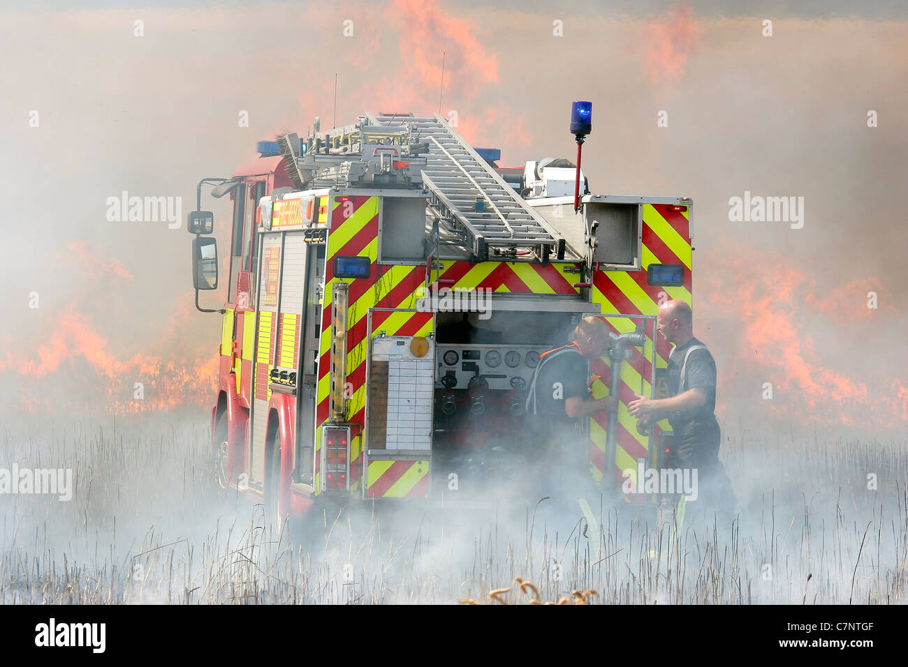 Fire engine in the middle of a blazing field fire Stock Photo - Alamy