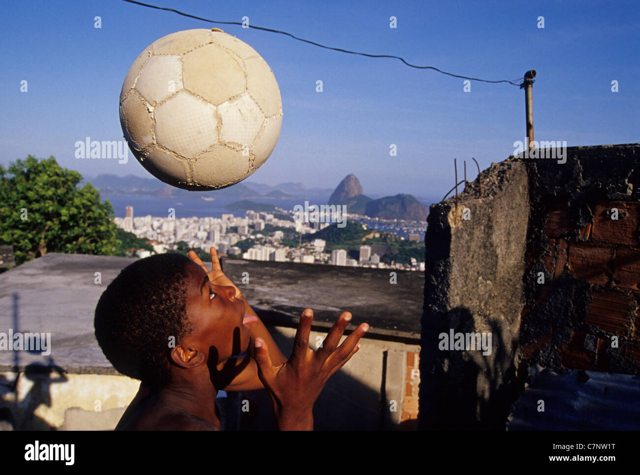 Child plays soccer in Rio de Janeiro favela Brazil Sugar Loaf mountain ...