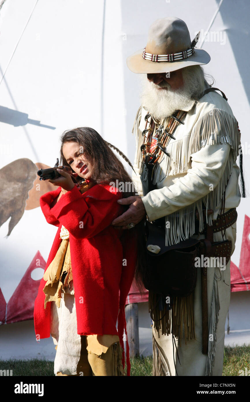 A young Native Americna Indian boy learning how to shoot a revolver ...