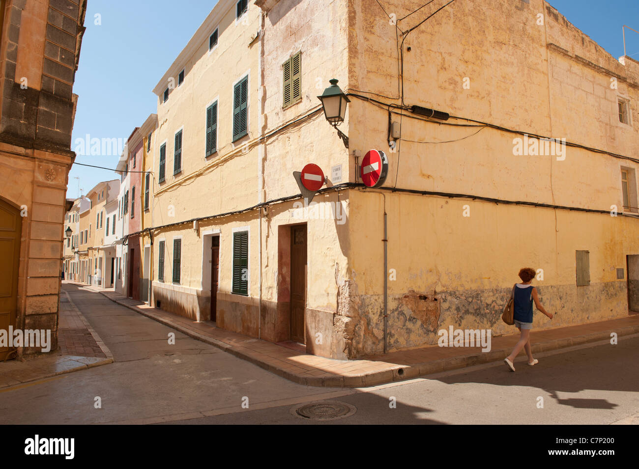 Alley in Minorca Spain, bright coloured building line a street with a ...