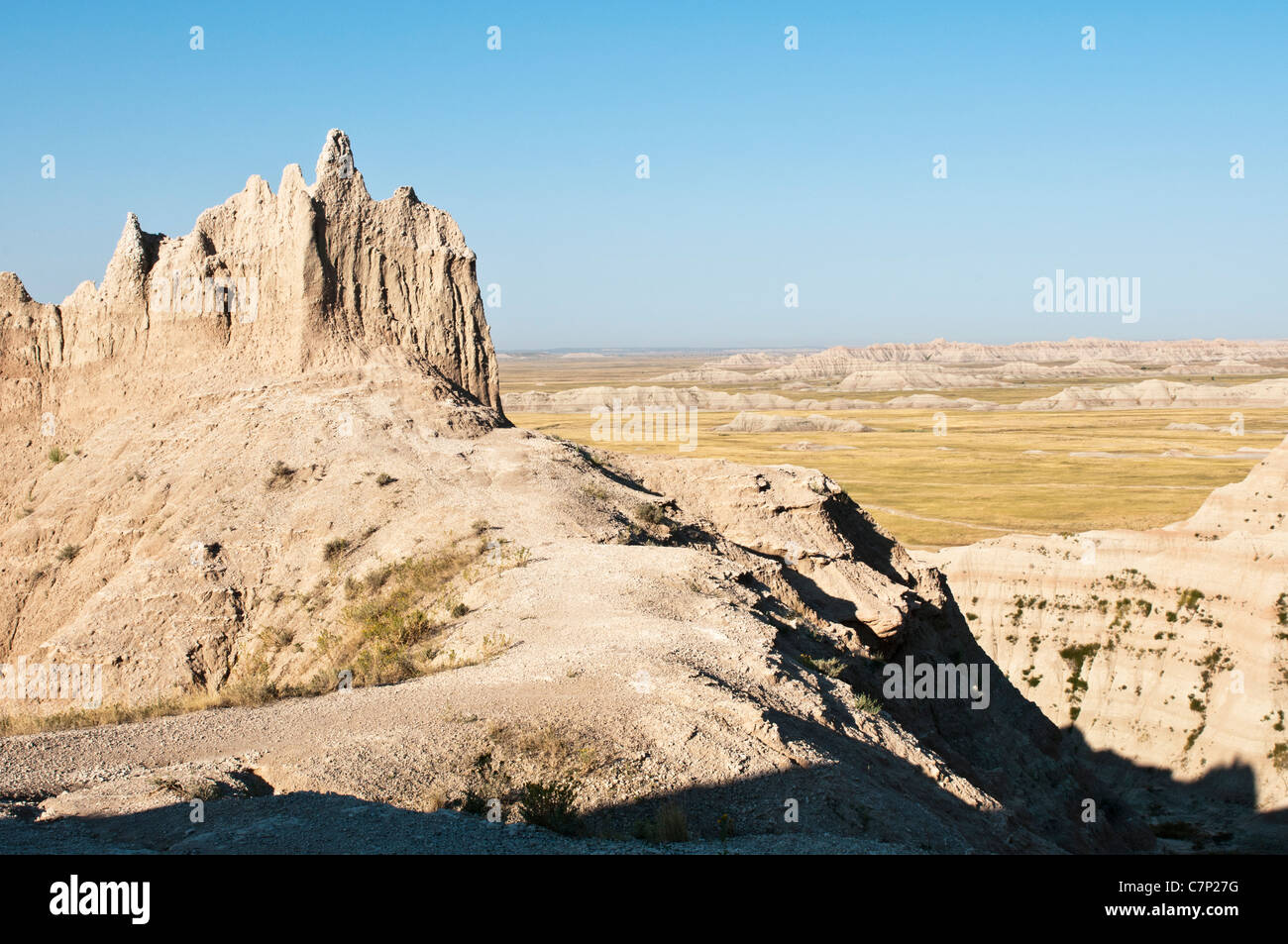 Sculpted buttes and spires rise above prairie grasslands in Badlands ...
