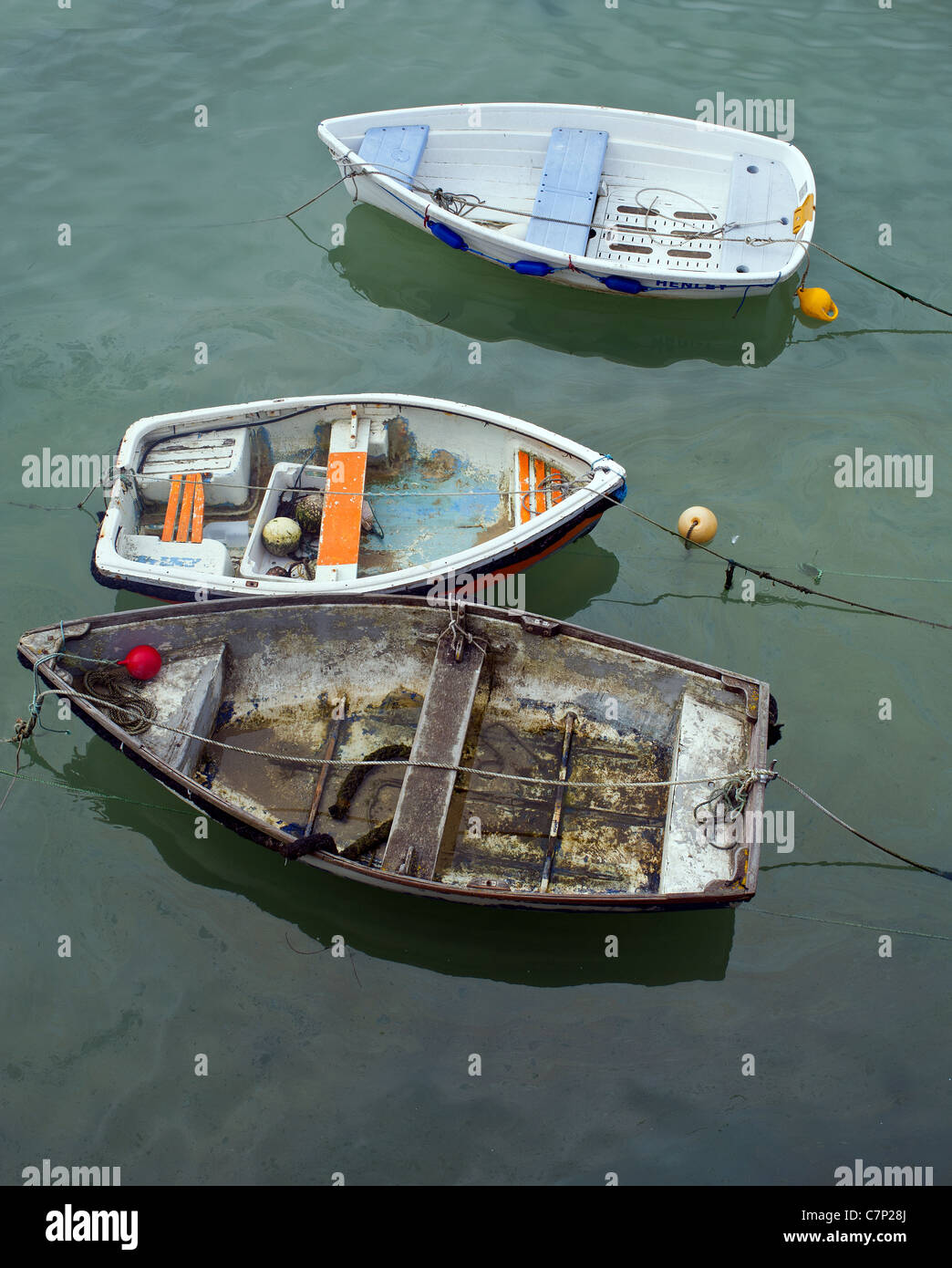 Three dinghies moored in a harbour Stock Photo - Alamy