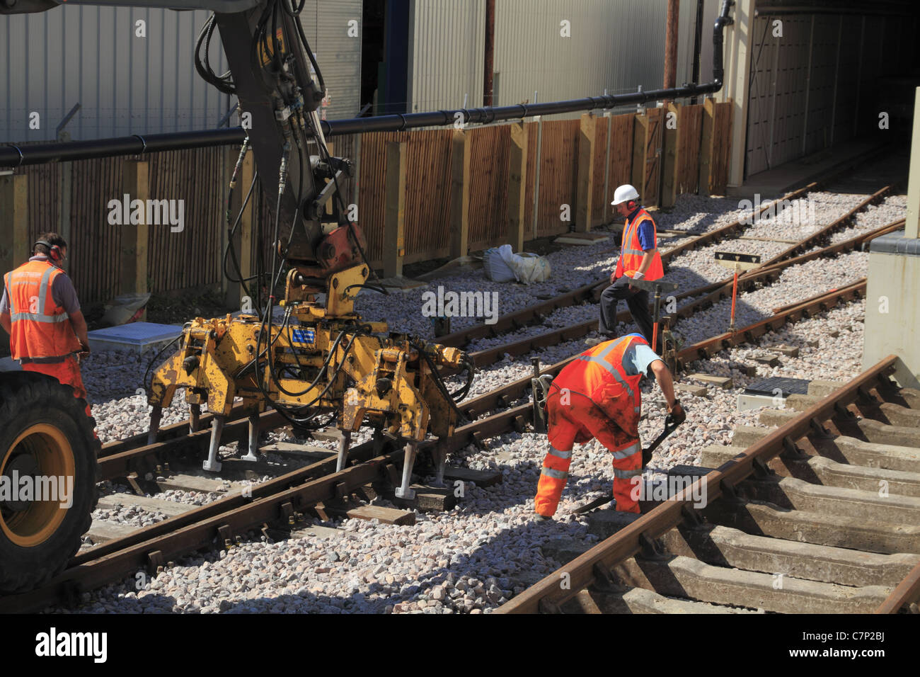 Men working on leveling the track at Bluebell Steam Railway, Sussex ...