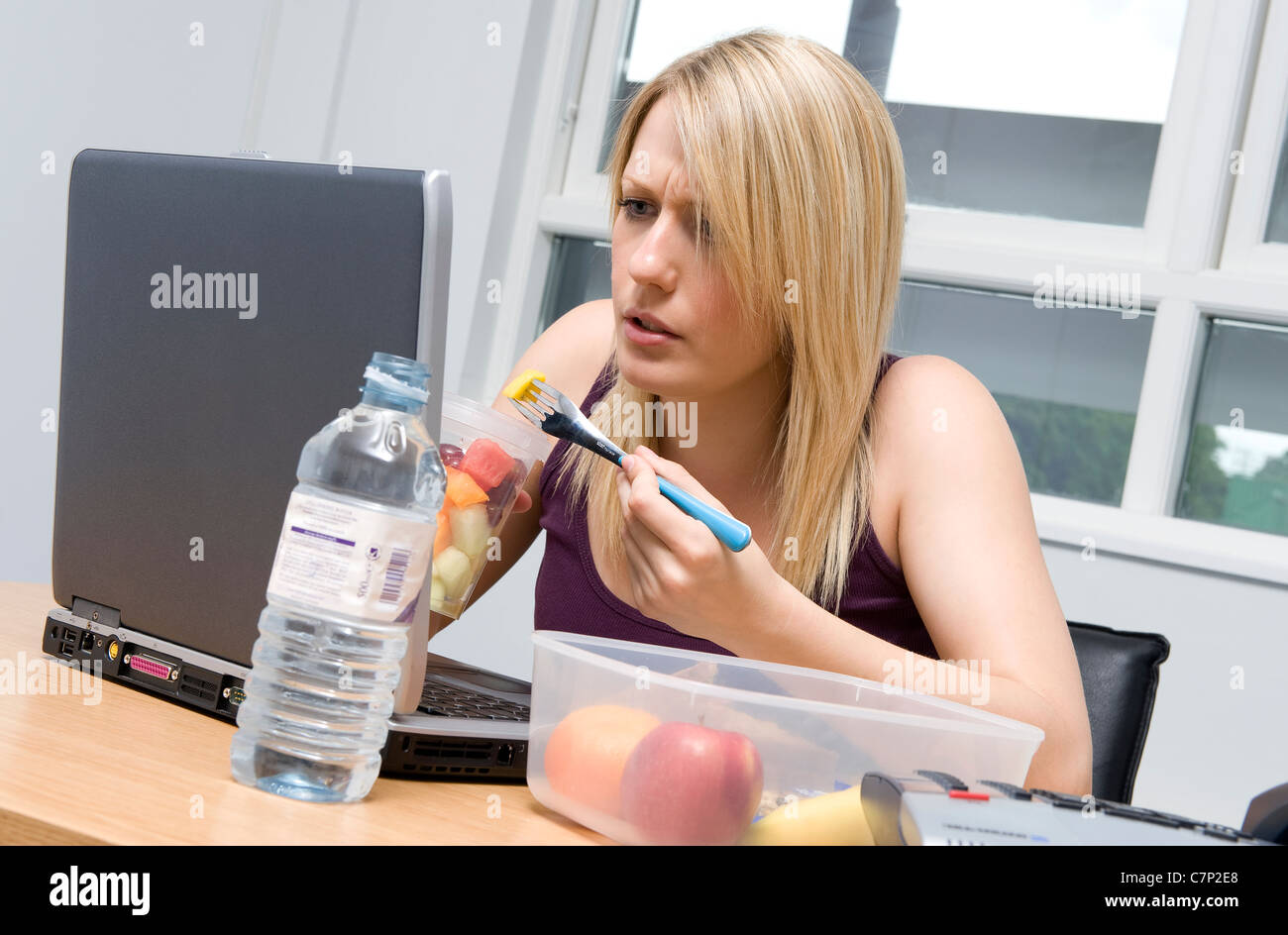 female office worker eating working lunch Stock Photo - Alamy