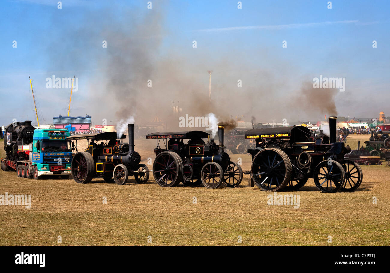three steam traction engines pulling a lorry loaded with a steam ...