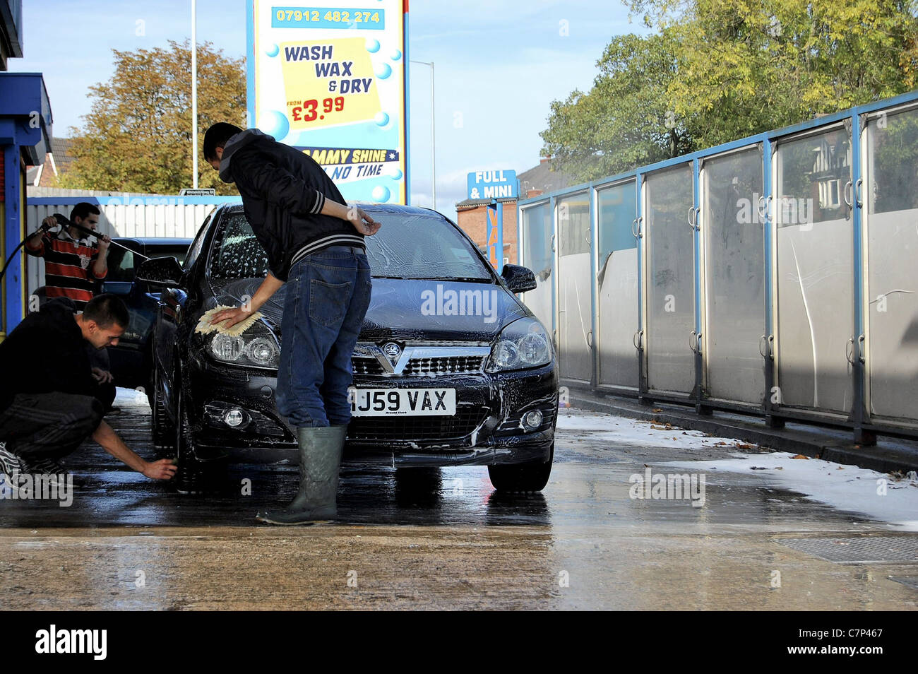 Using sponge on car at car wash while wheels being worked on Stock ...