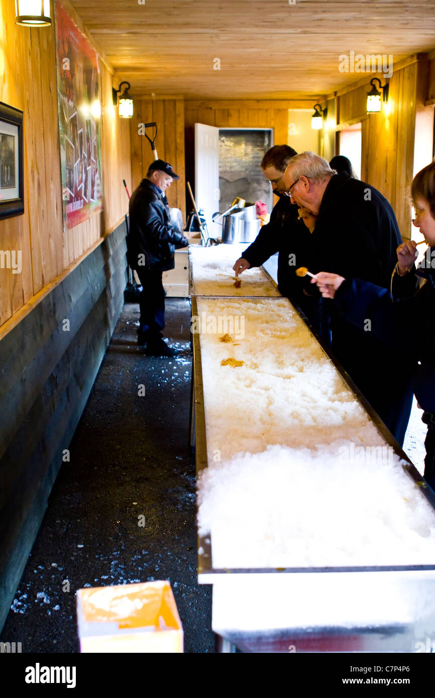 Hot maple syrup poured on snow also known as maple taffy or sugar on ...