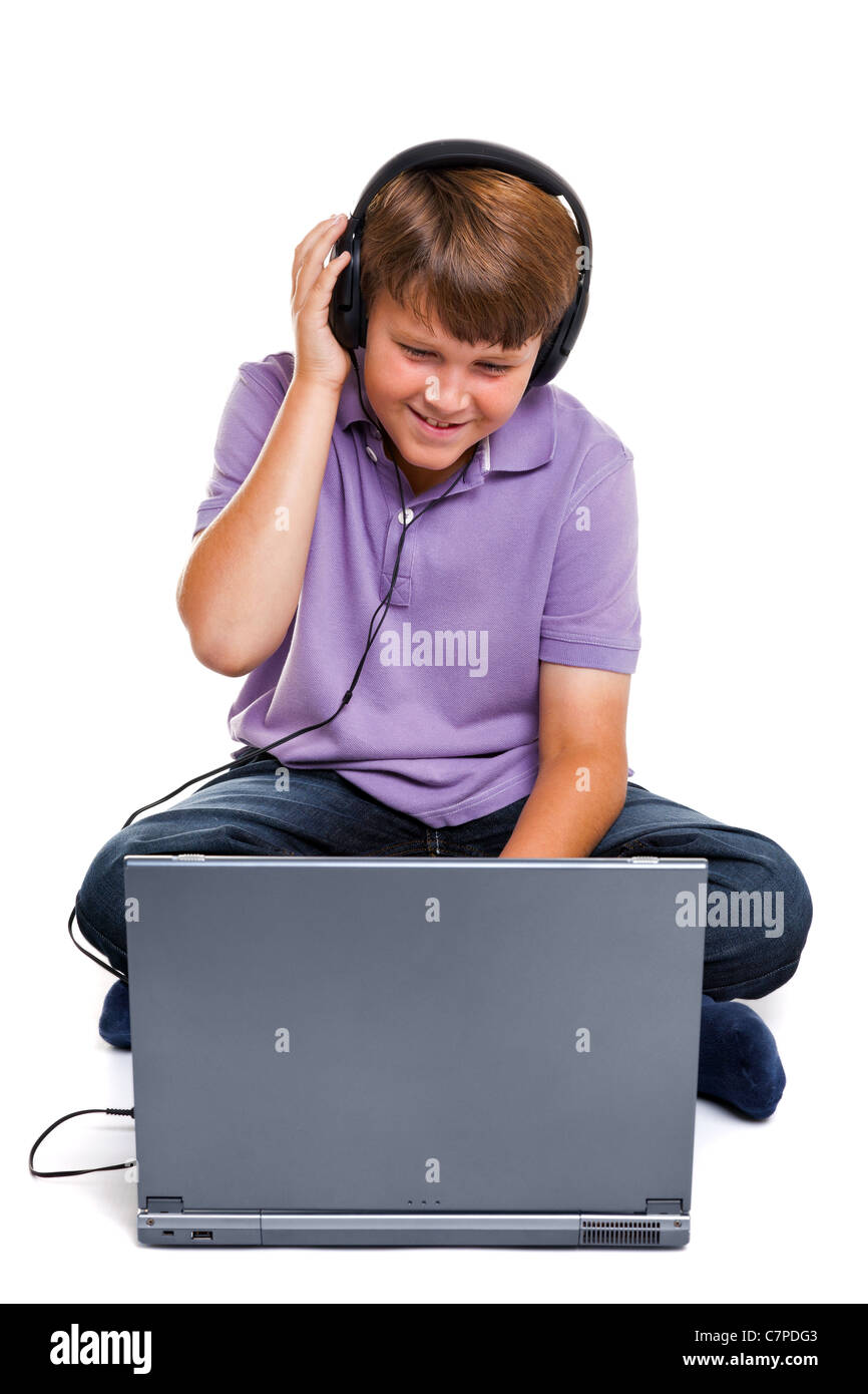 Photo of an 11 year old school boy wearing headphones sitting with a ...