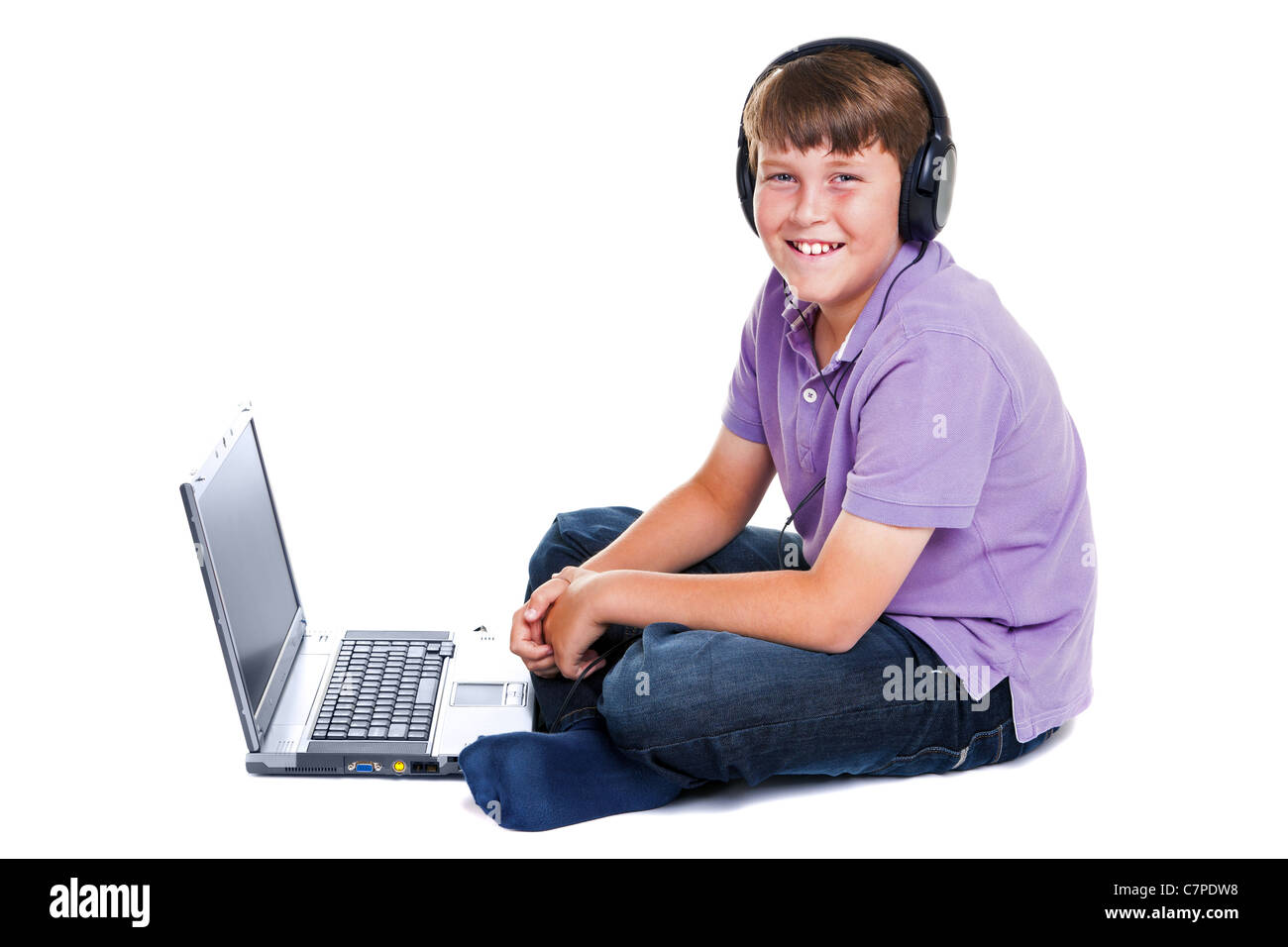 Photo of an 11 year old school boy wearing headphones sitting with a ...