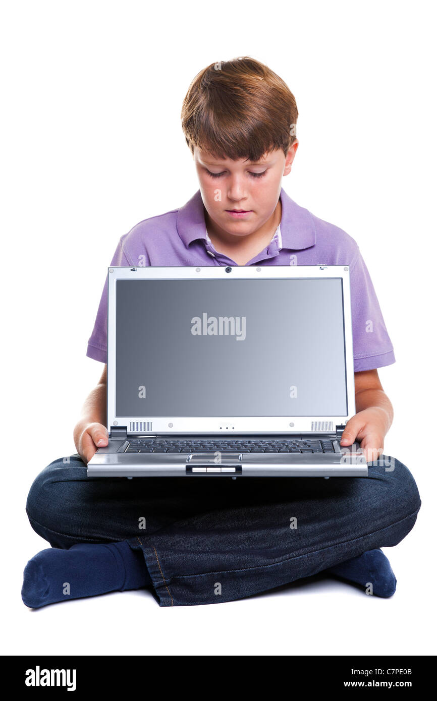 An 11 year old boy with a laptop computer, isolated on white with ...