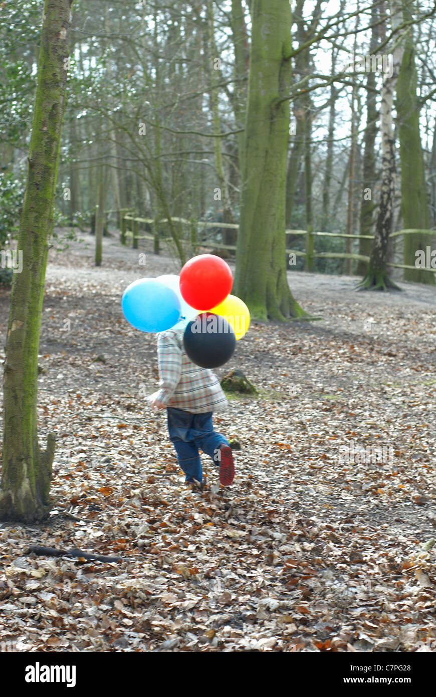 Boy carrying bunch of balloons outdoors Stock Photo - Alamy