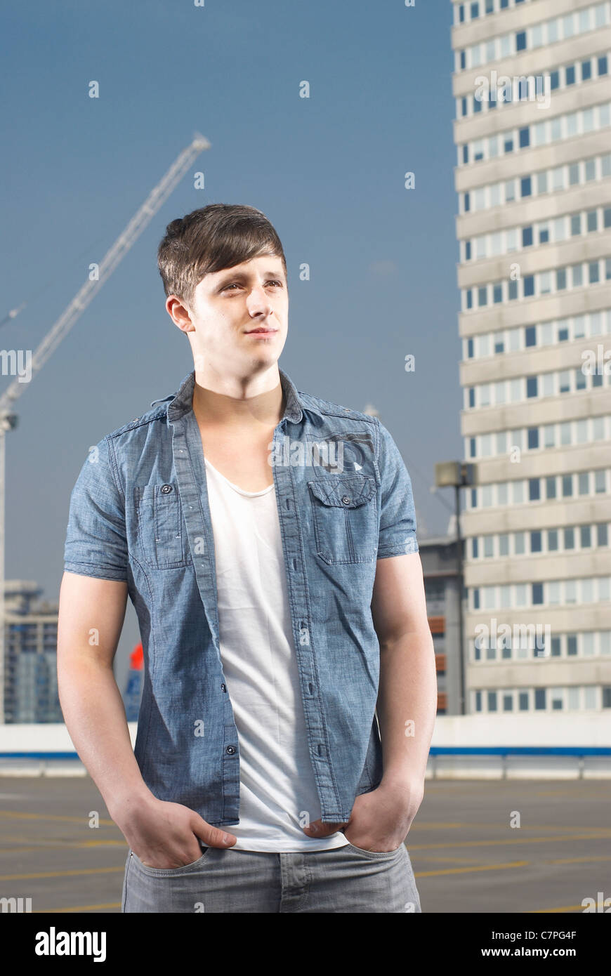 Man standing on urban rooftop Stock Photo - Alamy